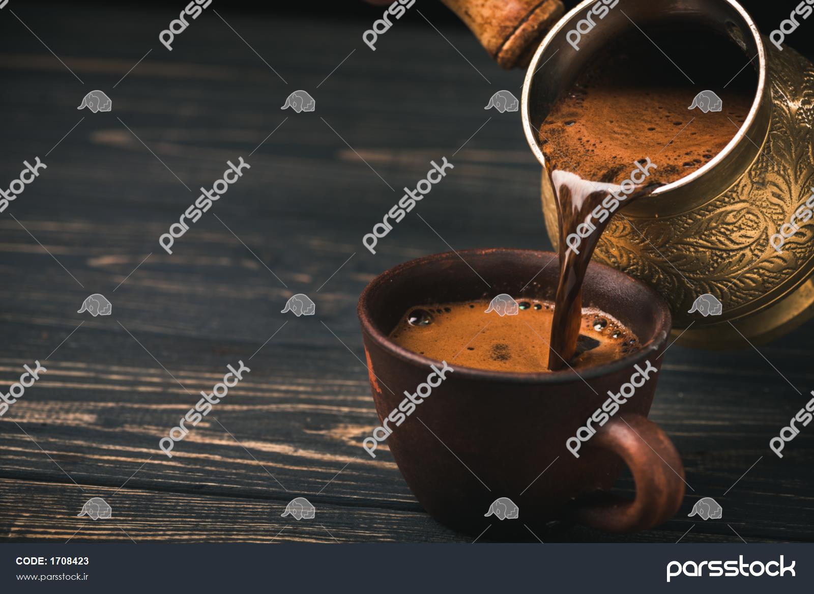 ریختن قهوه ترک در فنجان قدیمی روی زمینه چوبی 1708423